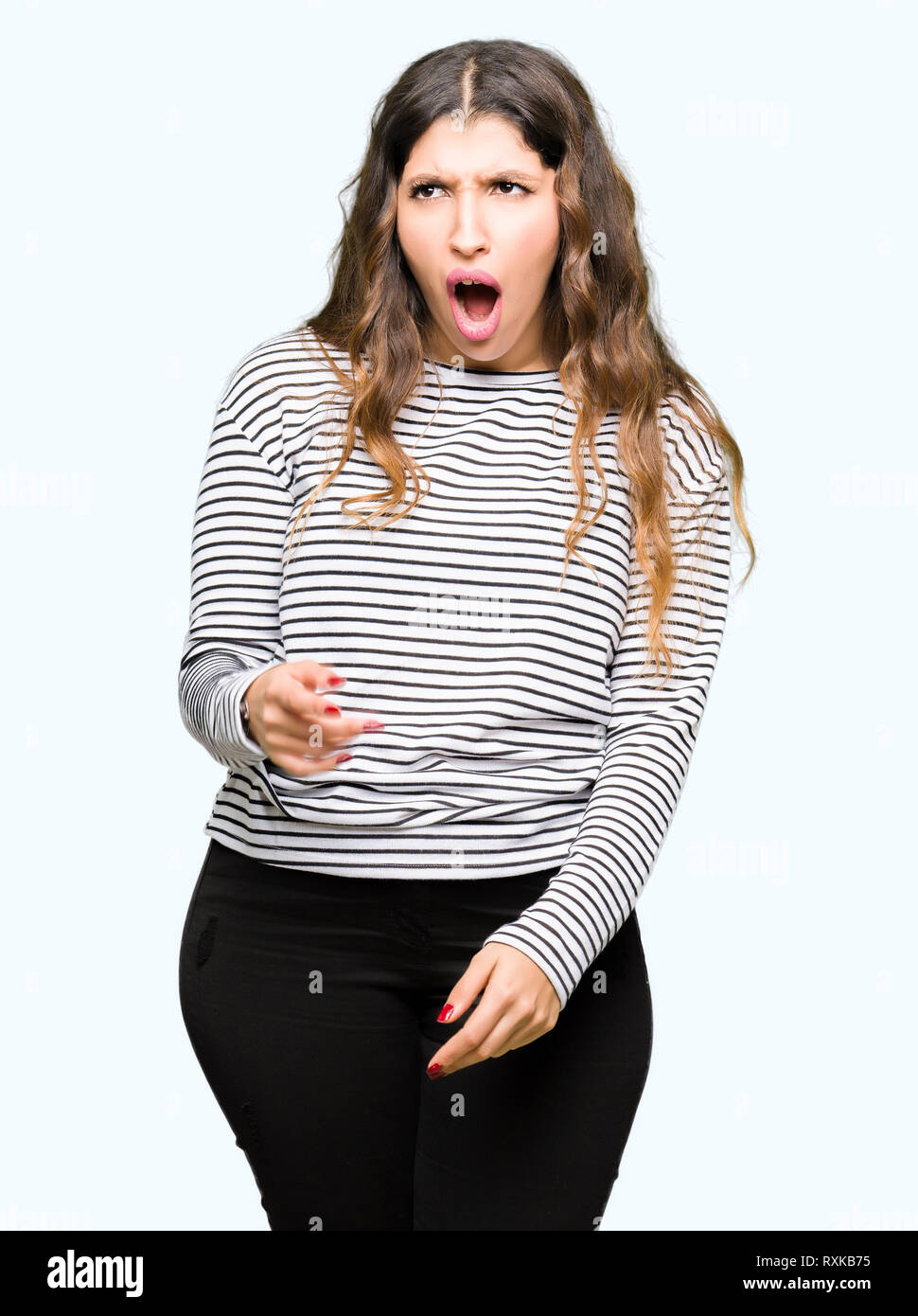 Young beautiful woman wearing stripes sweater In shock face, looking ...