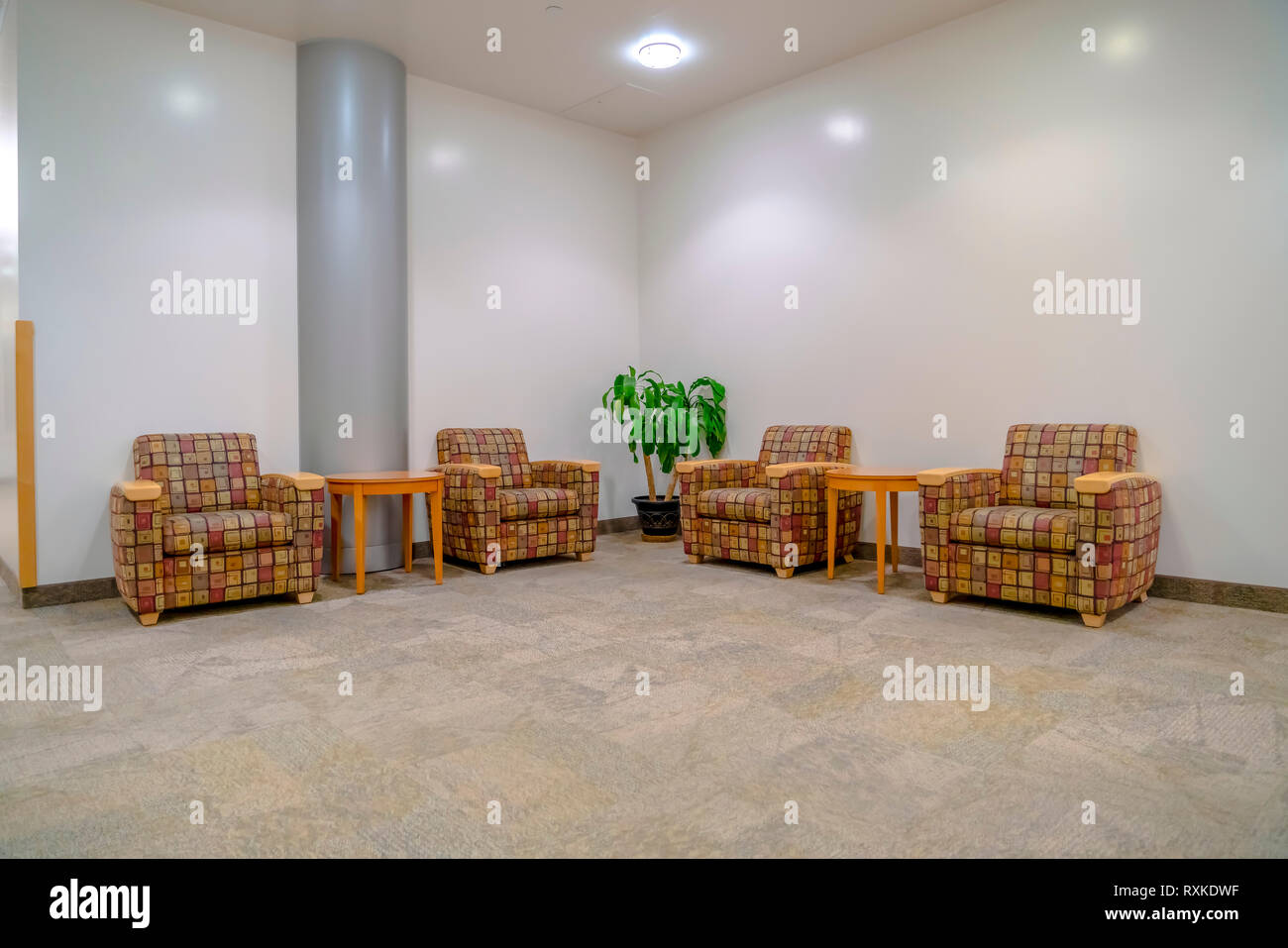 Upholstered chairs and wooden tables inside a room Stock Photo - Alamy