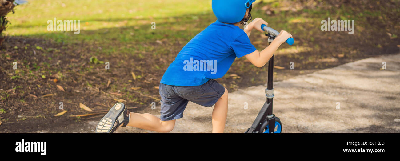 Boy riding scooters, outdoor in the park, summertime. Kids are happy ...