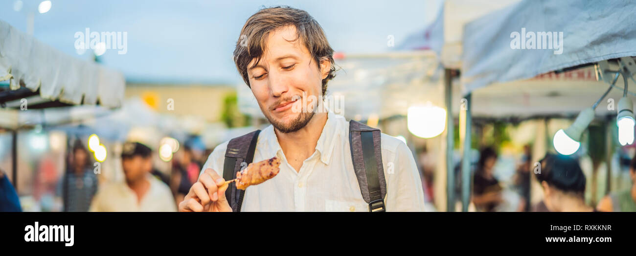 Young man tourist on Walking street Asian food market. BANNER, LONG ...