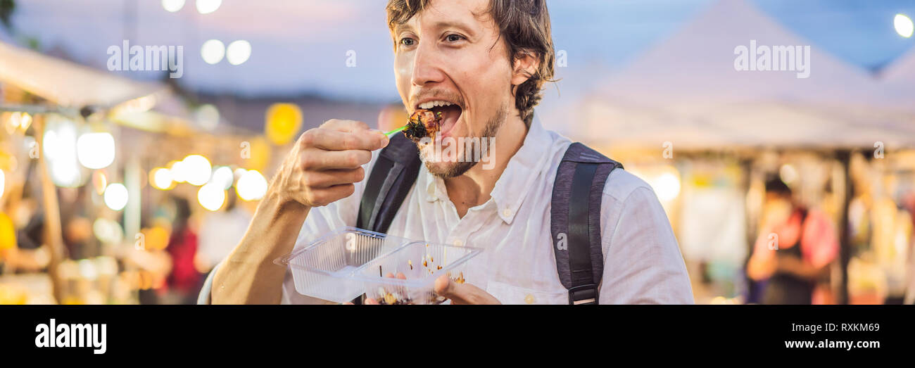 Young man tourist on Walking street Asian food market. BANNER, LONG ...
