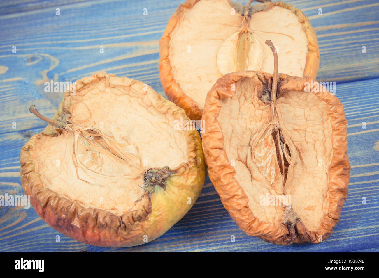 Spoiled wrinkled apple with mold on blue boards, concept of unhealthy ...