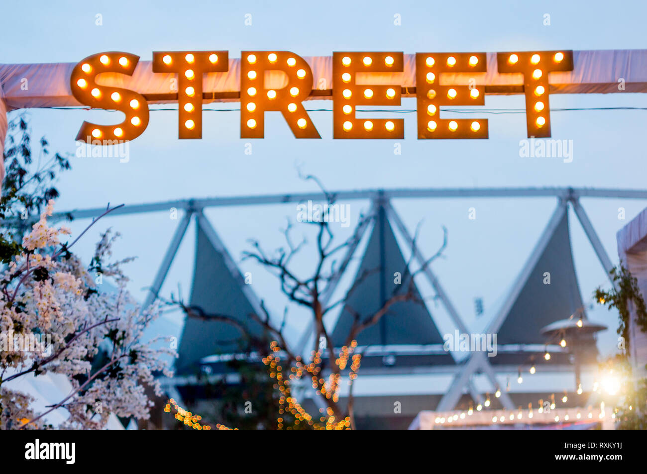 Lit street sign with bulbls with building architecture in the ...
