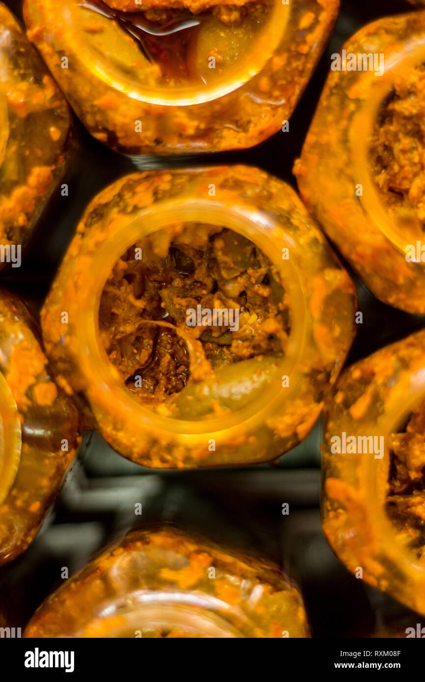 top view of open glass jars filled with freshly prepared spicy pickles ...