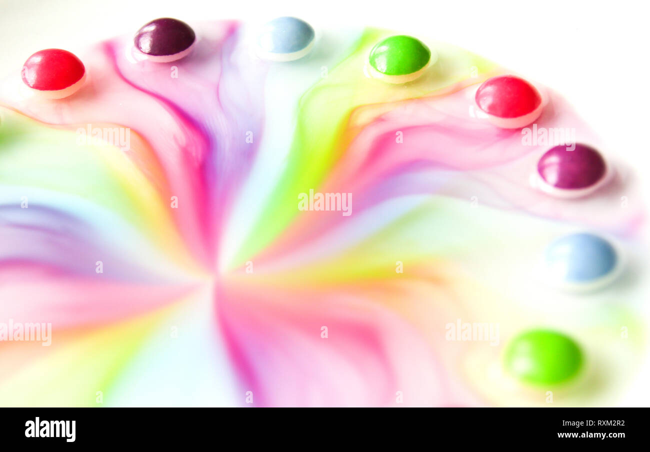 The candies are dissolving in the water and are making a colorful show ...