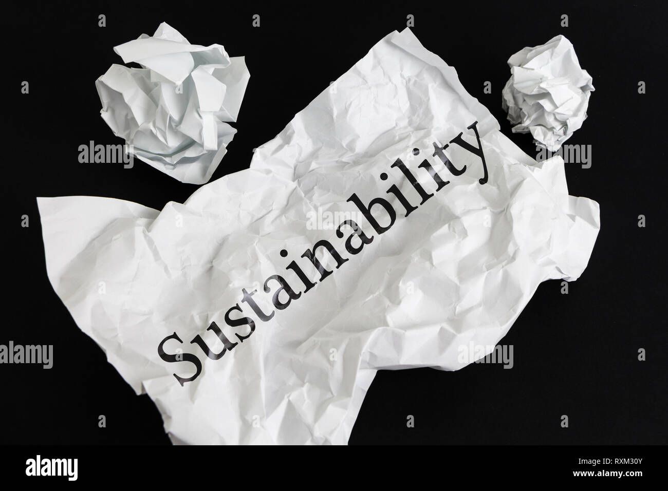 Crumpled paper sheet with word Sustainability isolated on black Stock ...