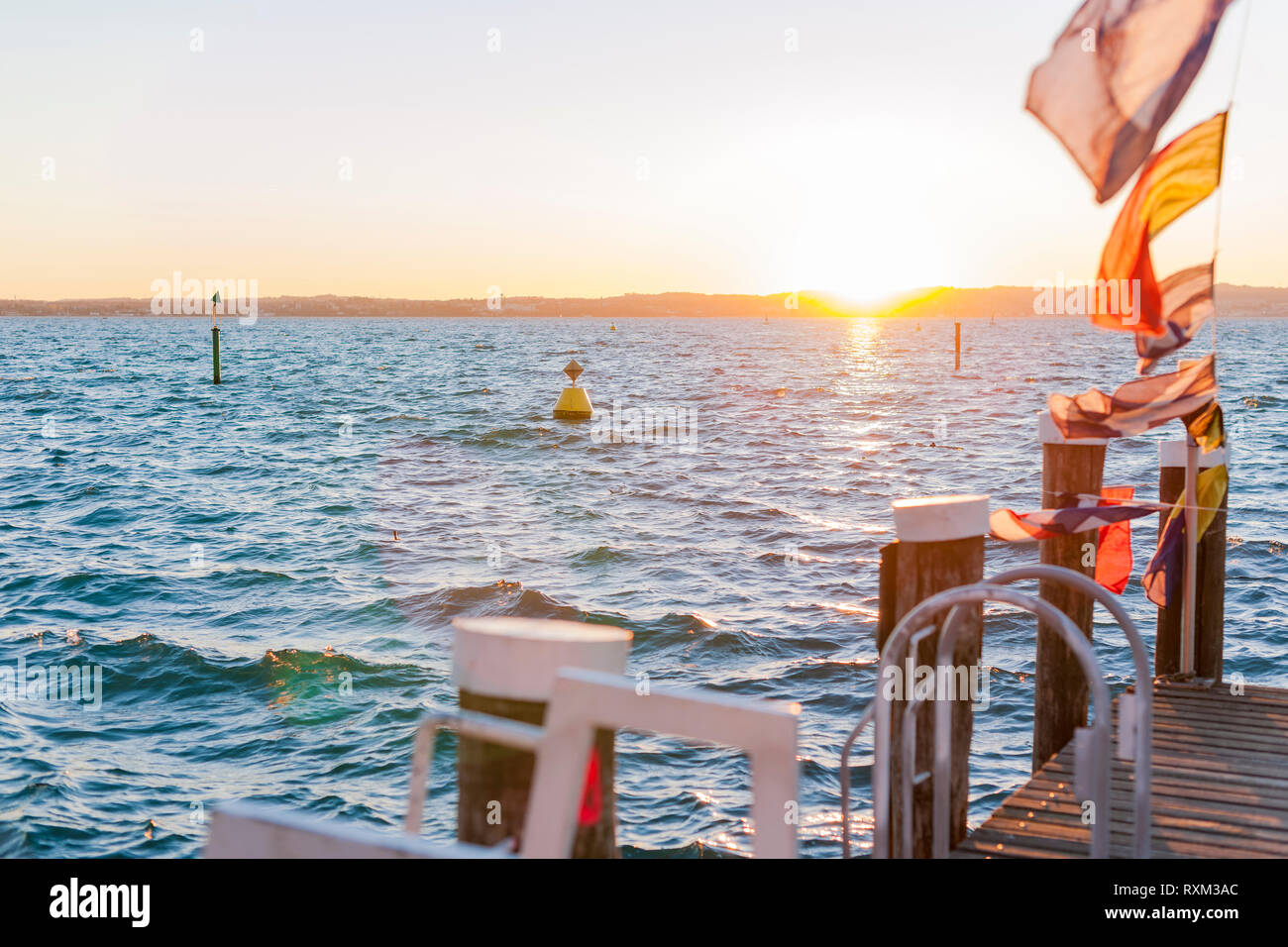 Sunset with red-yellow sun on a lake or sea. Sky, shore, sun and water ...