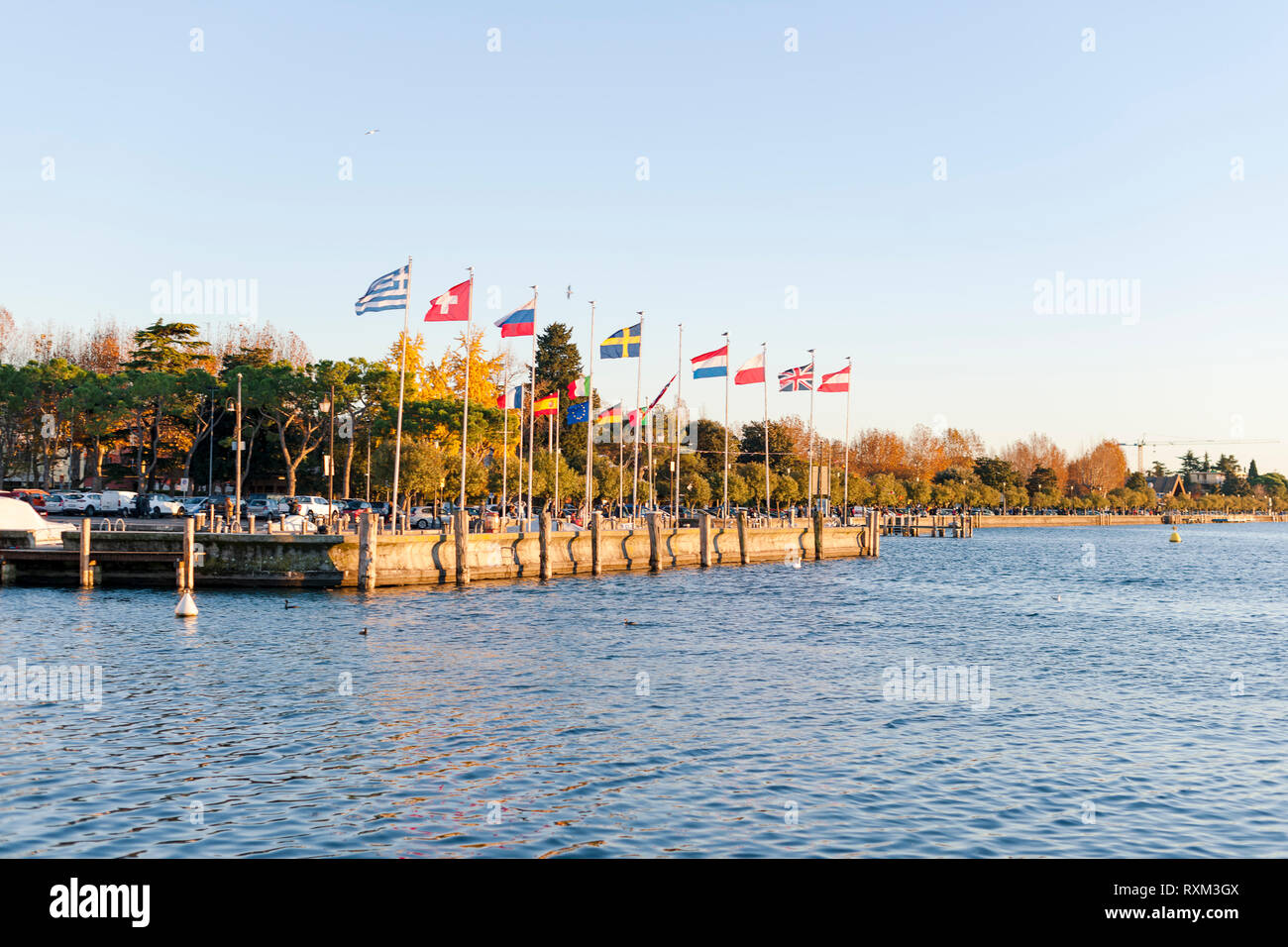 Sunset with red-yellow sun on a lake or sea. Sky, shore, sun and water ...