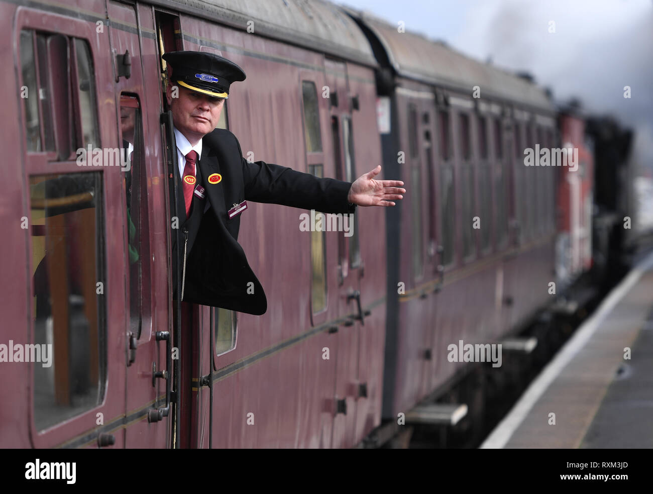 A guard signals as a steam locomotive pulls away during the Southern ...