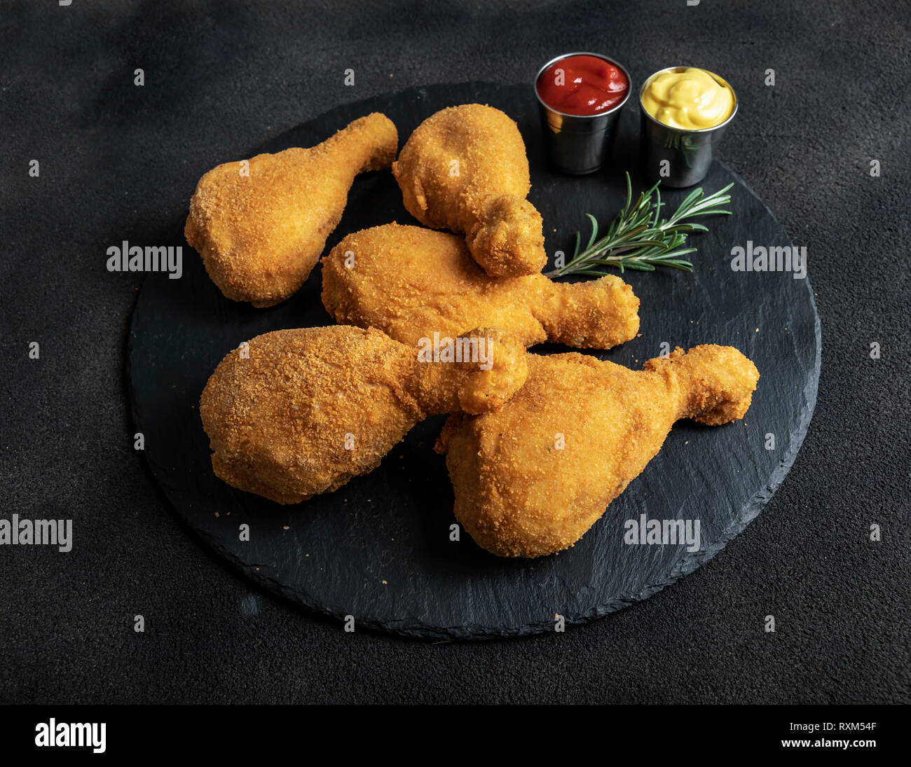 crispy fried chicken legs breaded golden color on black background ...