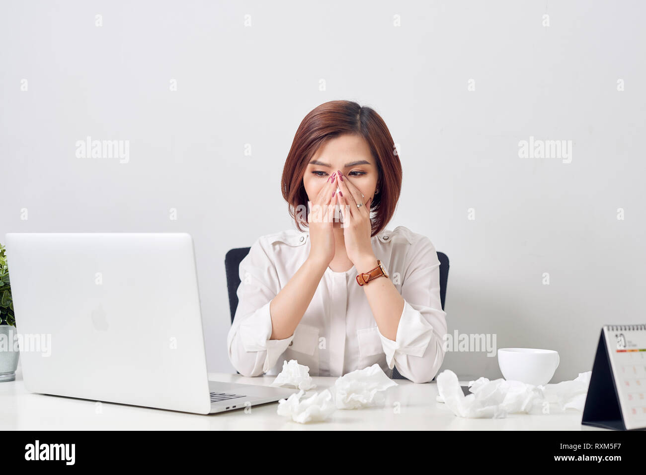 Sad exhausted woman with tissue suffering from cold while working with ...