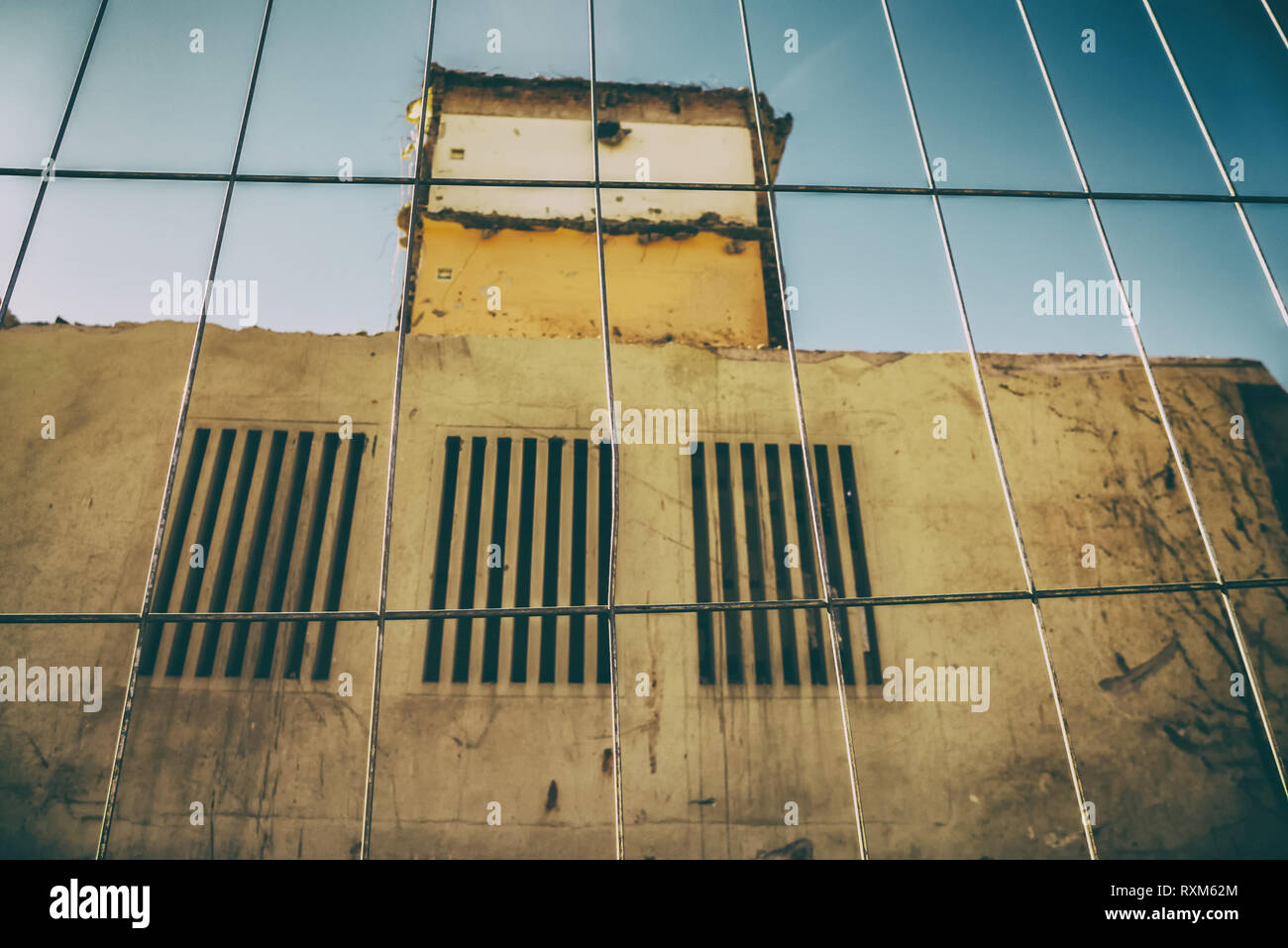 An old and wrecked building behind a metal fence Stock Photo - Alamy