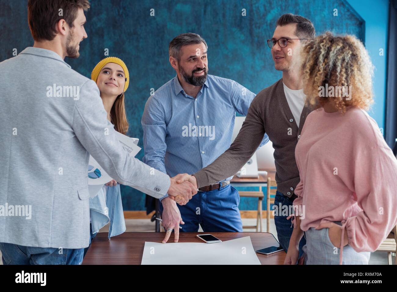 Glad to work with you! Young modern men in smart casual wear shaking ...