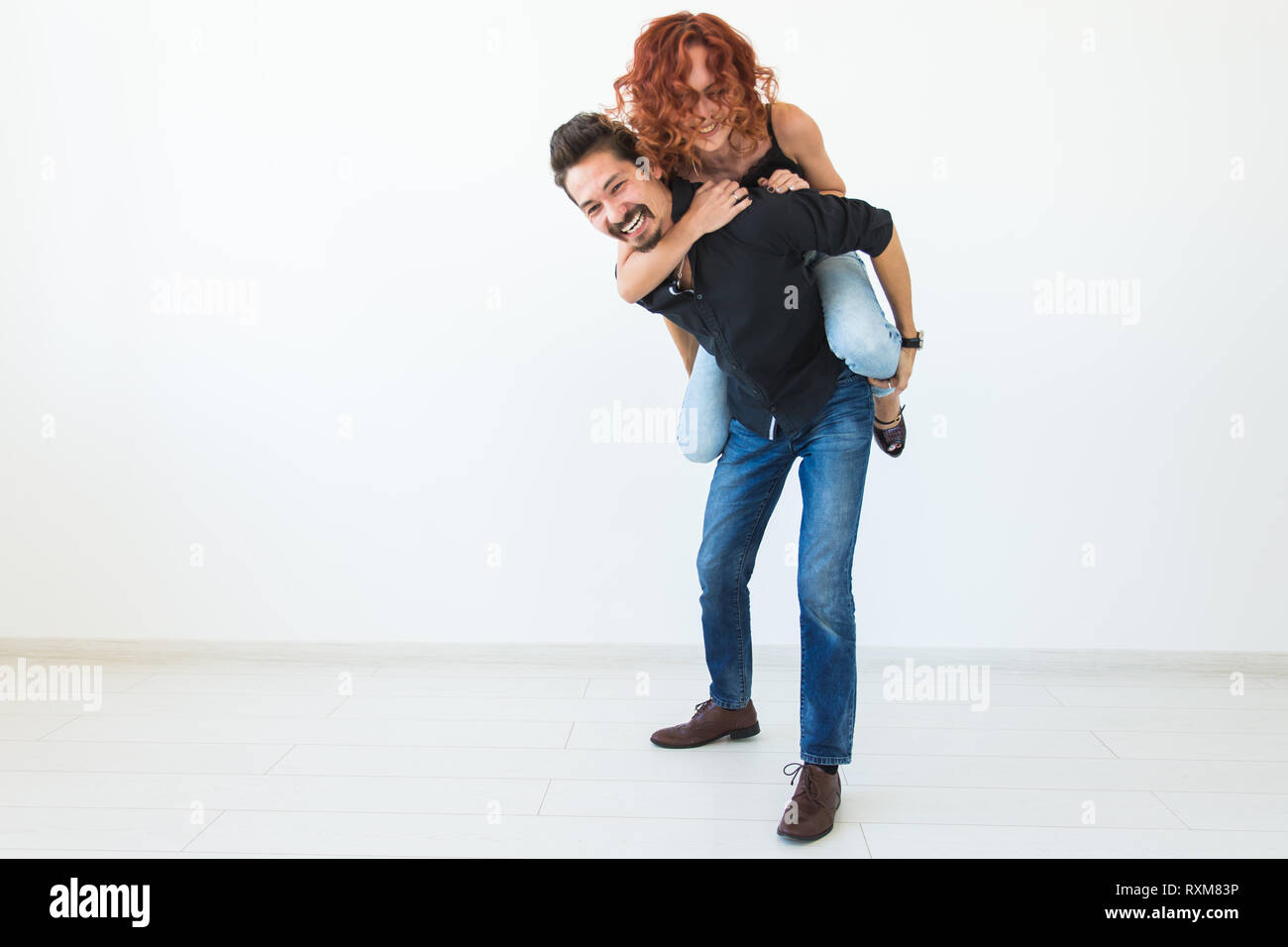 People and love concept - Beautiful pretty woman sitting at man's back ...