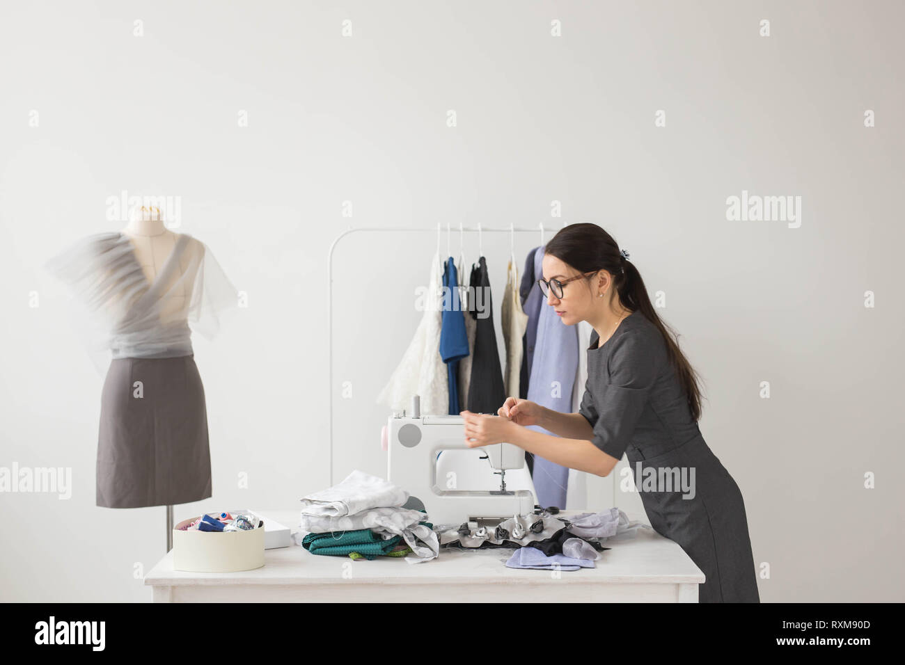 Dressmaker, fashion designer and tailor concept - Young dressmaker ...