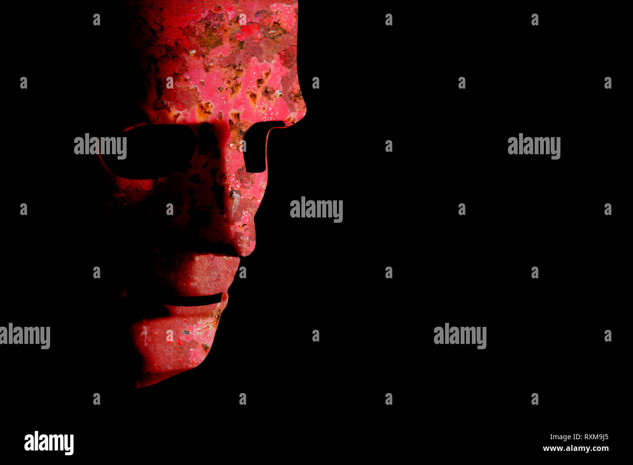 Old robotic decaying face mask. Rusty red grunge texture on a black ...