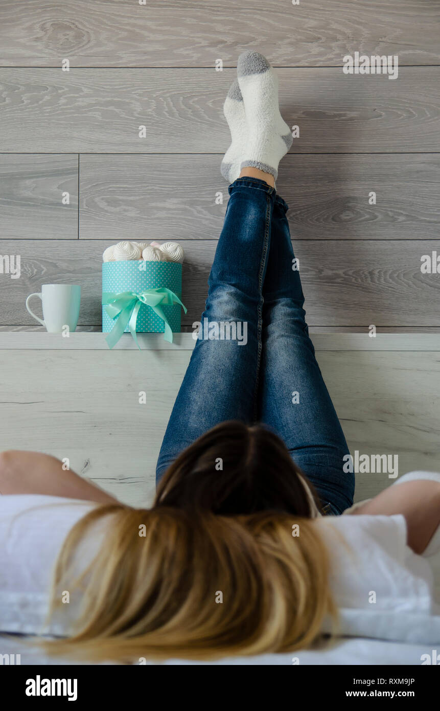 Time to have a rest. Box with meringues , white cup and woman lying ...