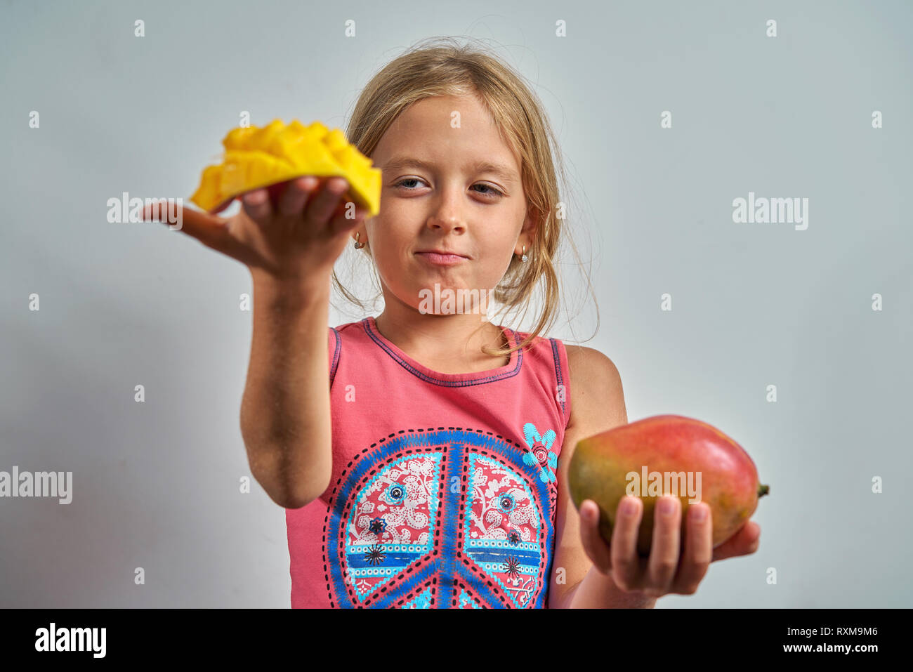 little girl eating mango Stock Photo - Alamy