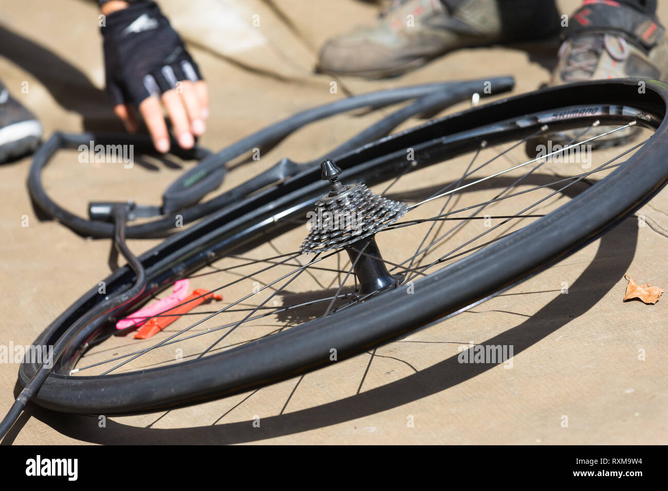 a bicycle wheel lies on the ground while a tube is being pumped or ...