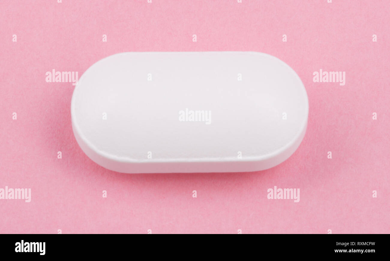 White Pill on Pink Background Stock Photo - Alamy