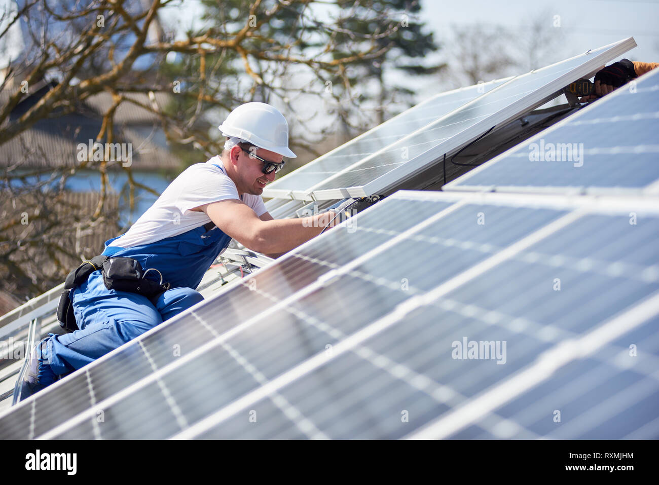 Male worker installing solar photovoltaic panel system. Electrician ...