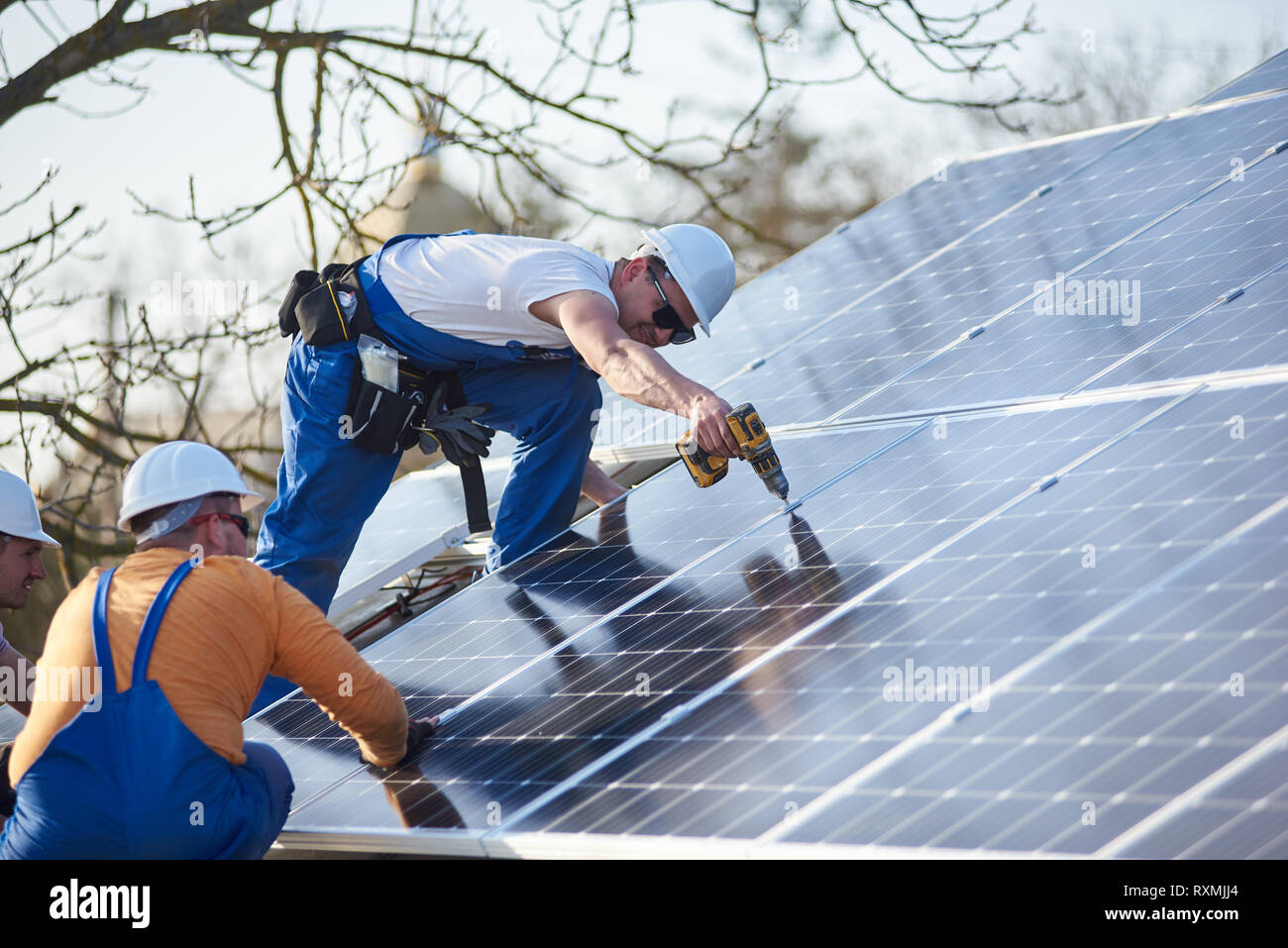 Male workers installing stand-alone solar photovoltaic panel system ...