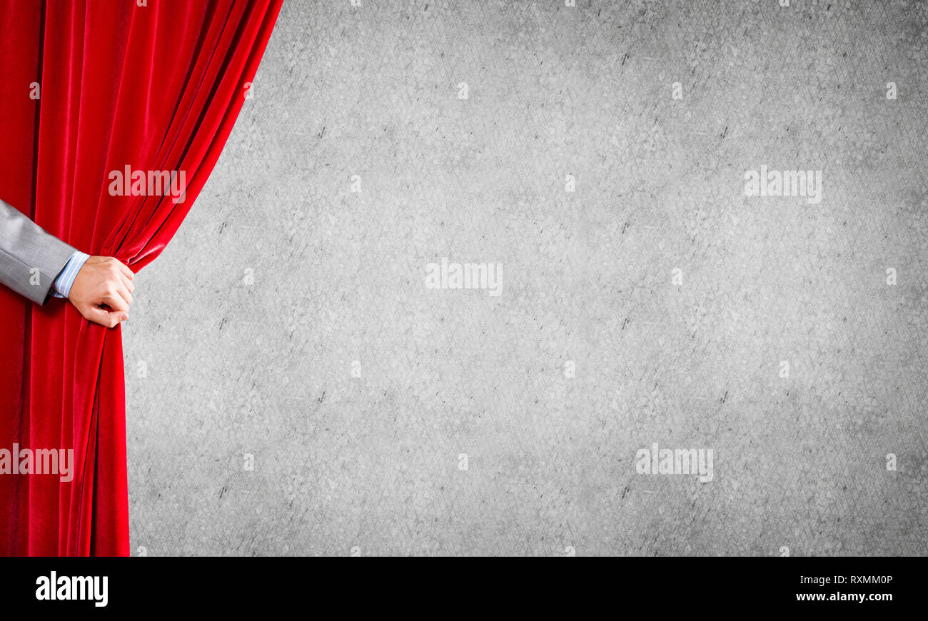 Concrete wall behind drapery curtain and hand opening it Stock Photo ...