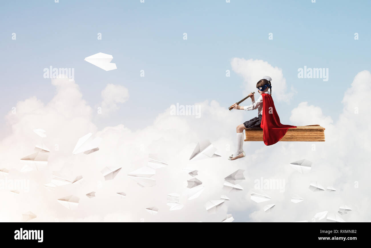 Girl power concept with cute kid guardian against cloudscape background ...