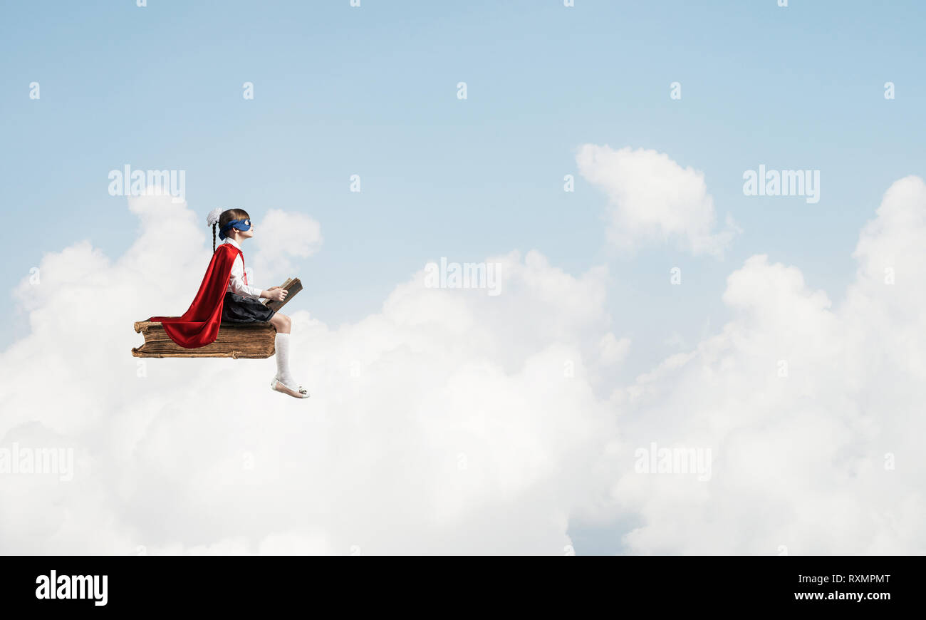 Girl power concept with cute kid guardian against cloudscape background ...