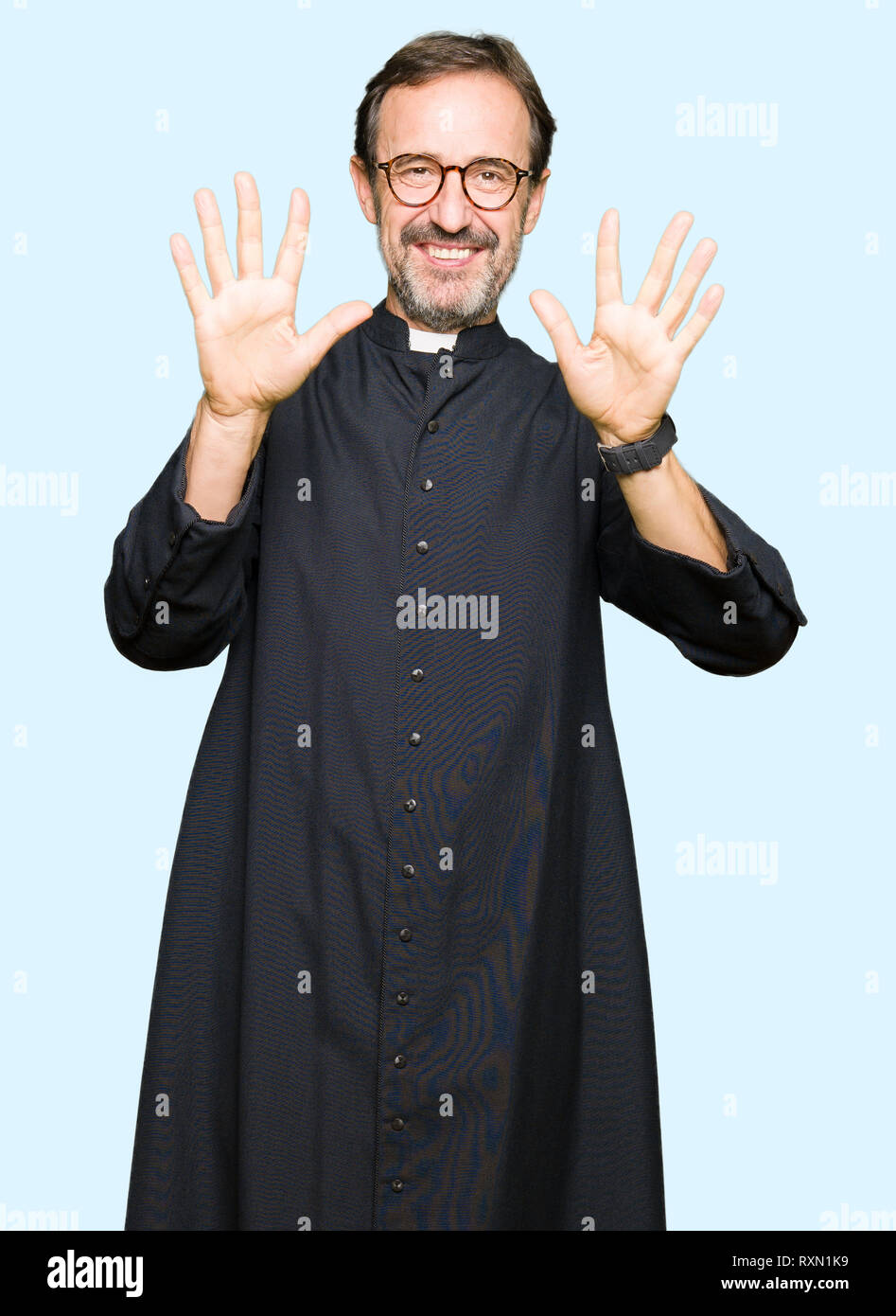 Middle age priest man wearing catholic robe showing and pointing up ...