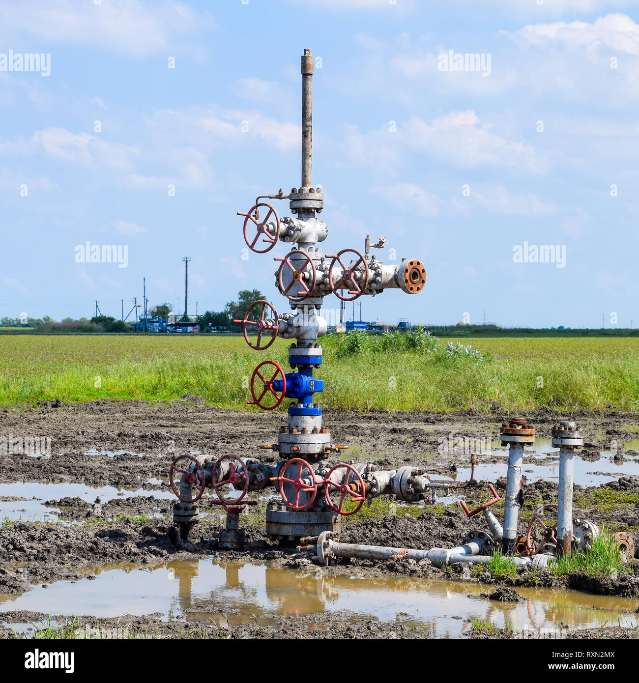 Oil well after repair in mud and puddles. Oil well wellhead equipment ...