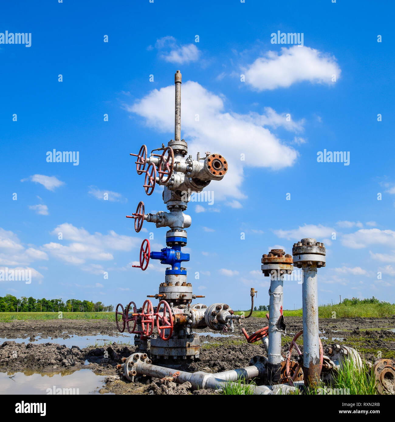 Oil well after repair in mud and puddles. Oil well wellhead equipment ...