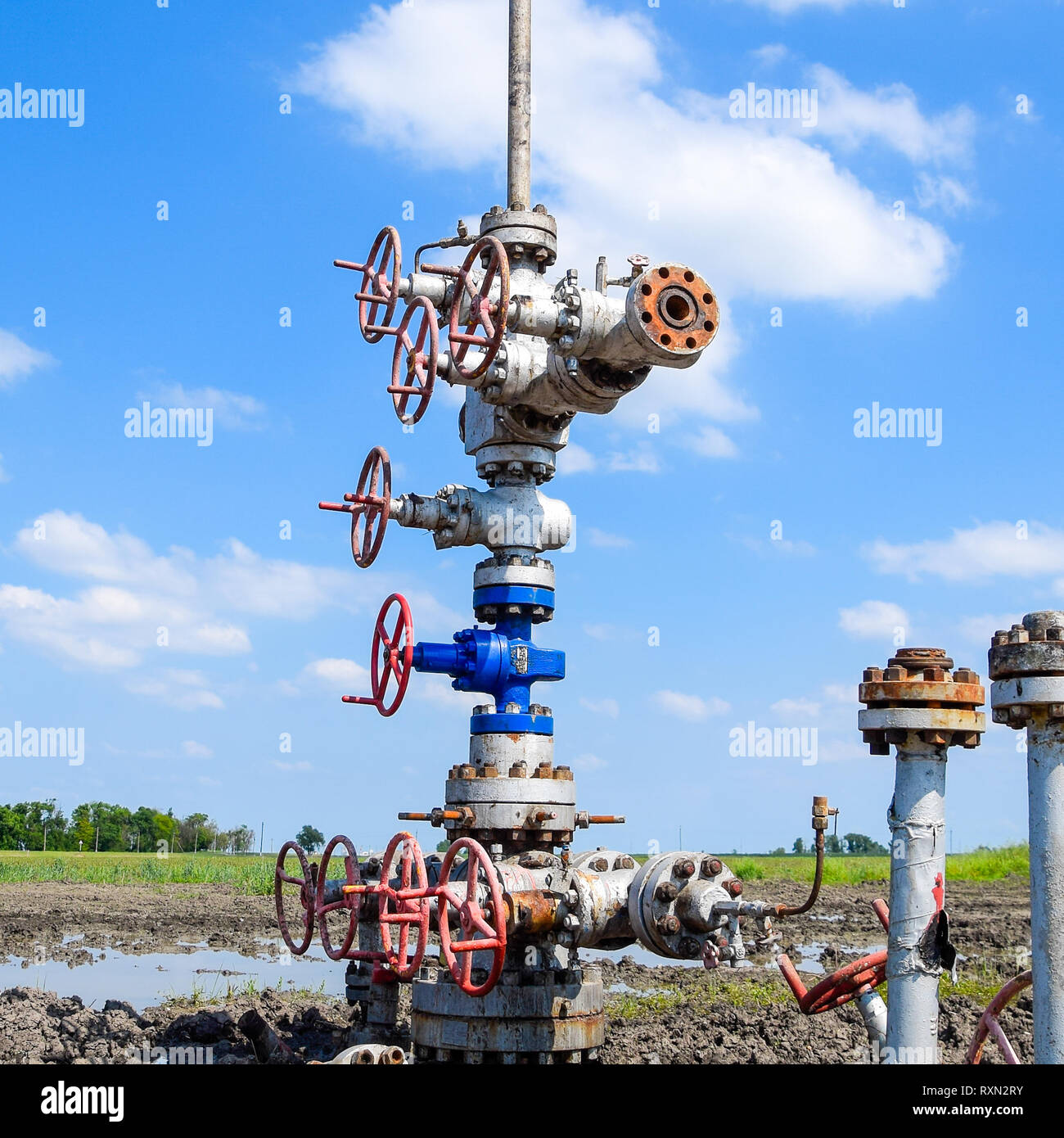 Oil well after repair in mud and puddles. Oil well wellhead equipment ...
