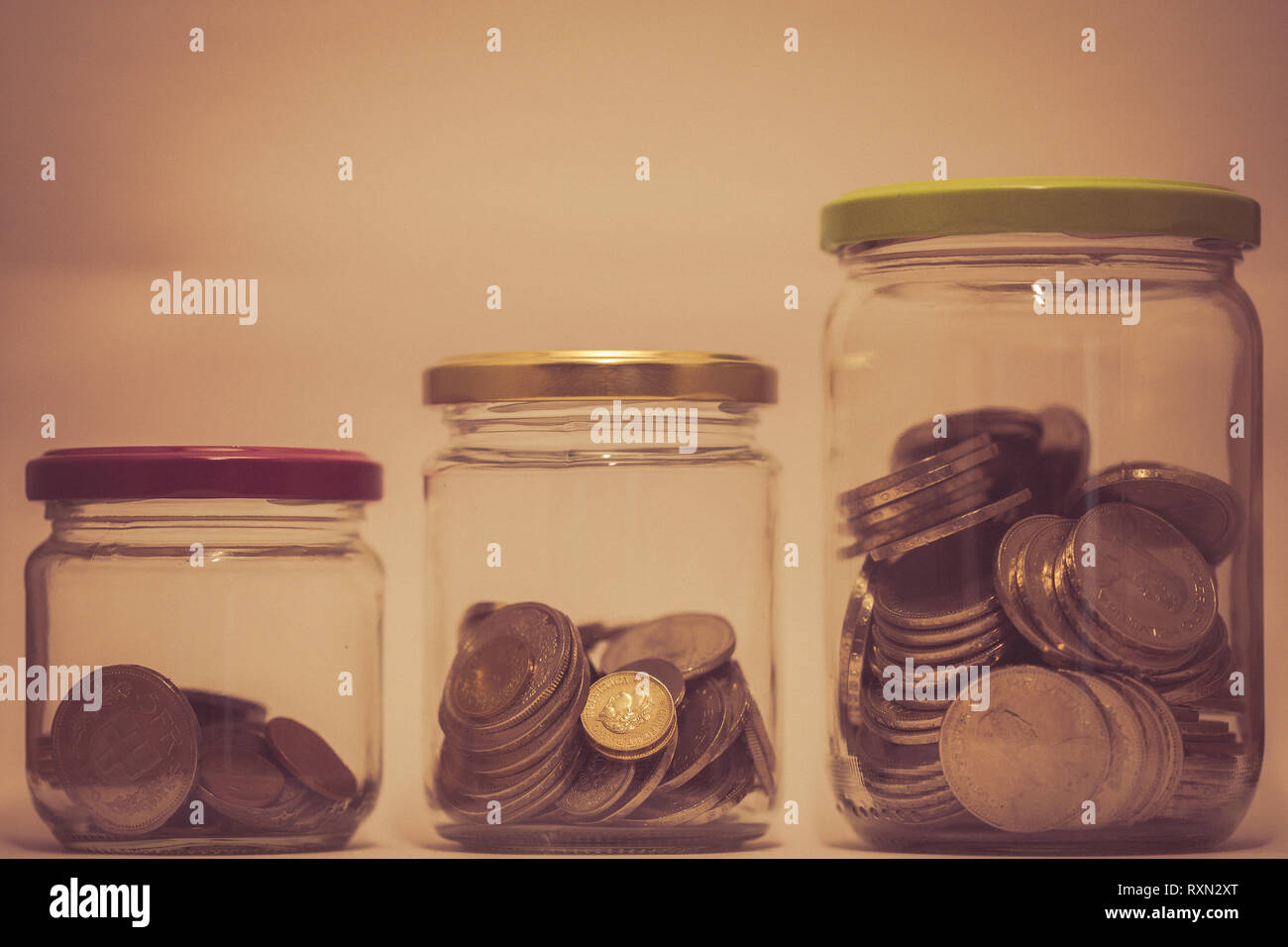 three glasses with increasing coins as a piggybank, savings Stock Photo ...