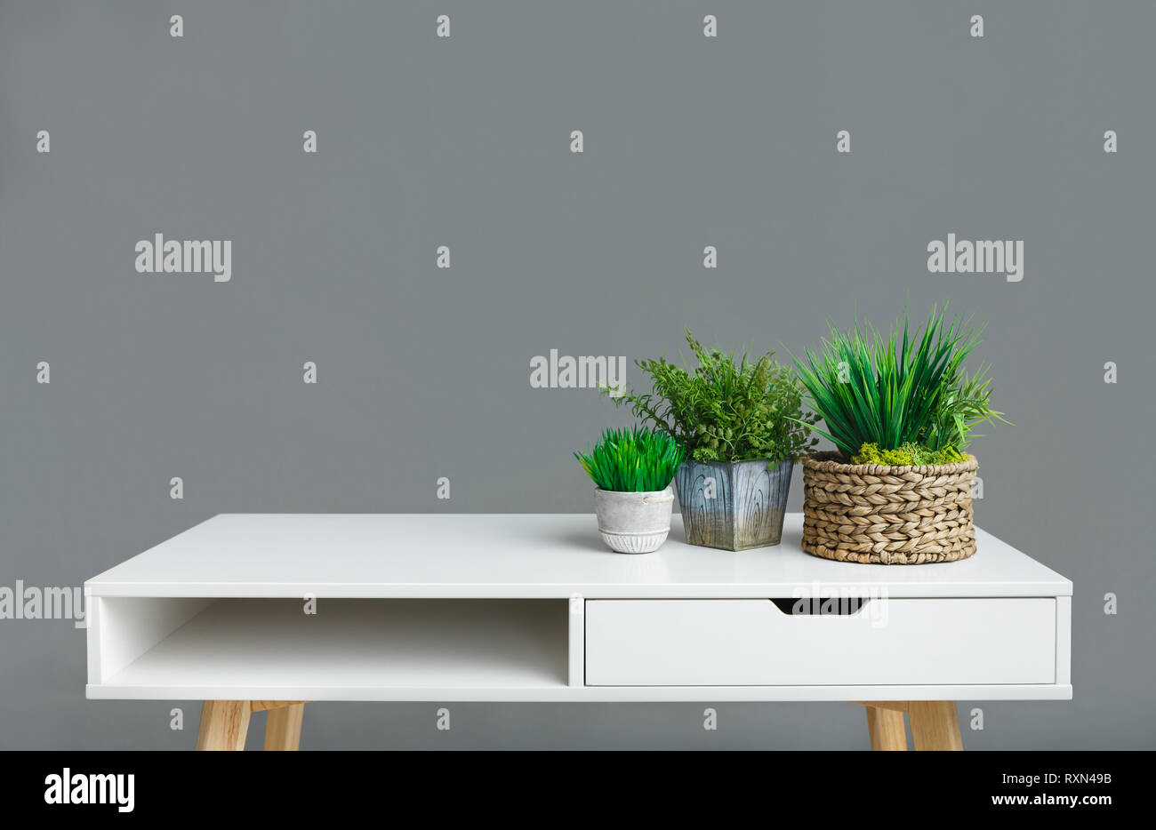 Pots with greenery on table Stock Photo - Alamy