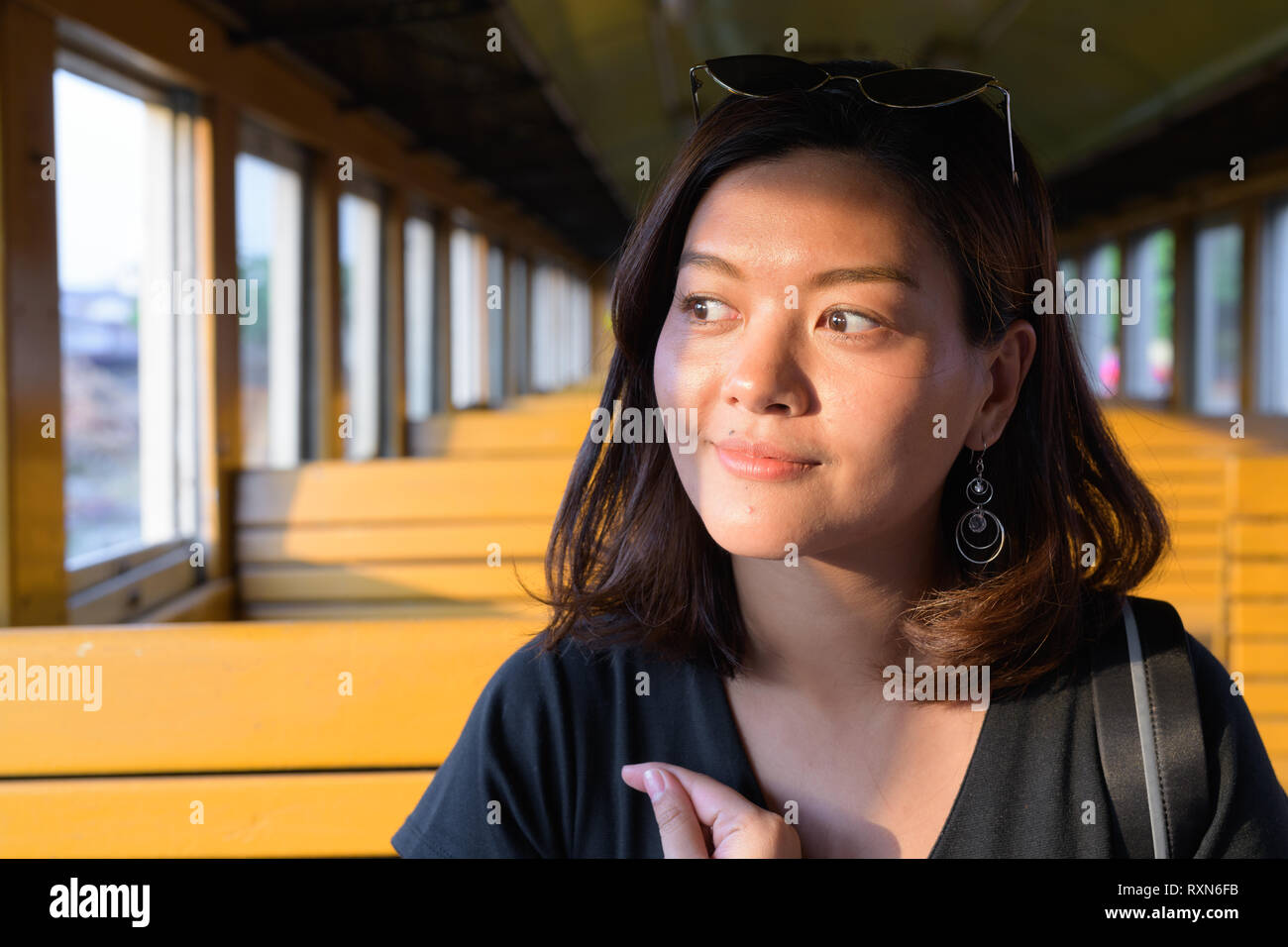 Face of young beautiful Asian tourist woman thinking inside the train ...