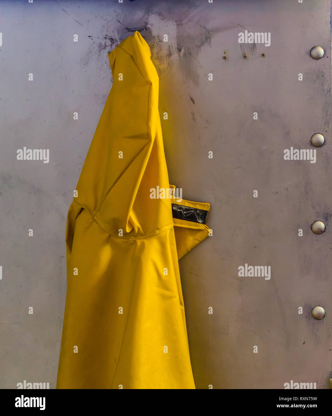 yellow raincoat hanging on a metal wall, Marine background, protective ...