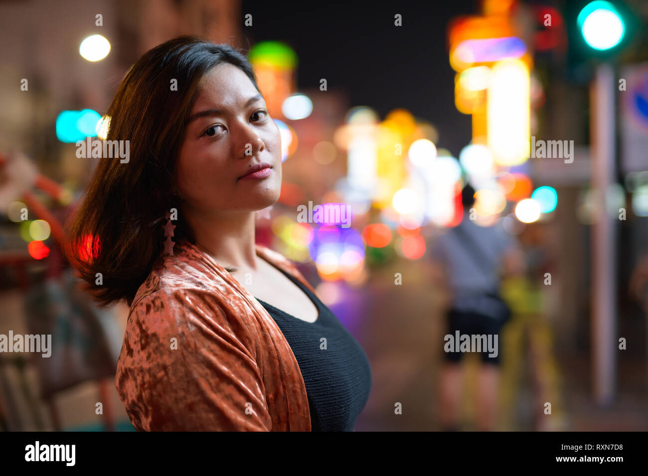 Profile view of young beautiful Asian tourist woman at Chinatown in ...