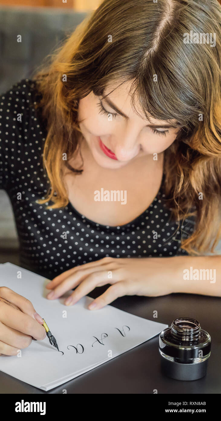 Calligrapher Young Woman writes phrase on white paper. Bible phrase ...
