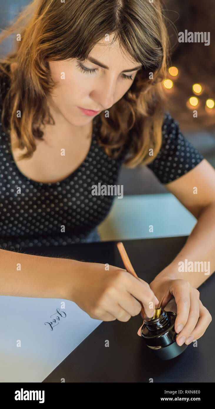 Calligrapher Young Woman writes phrase on white paper. Good morning ...