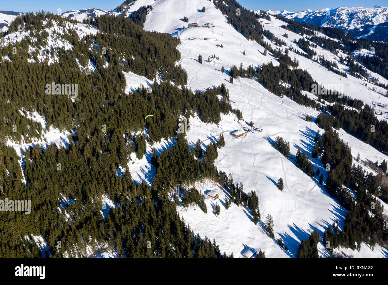 Aerial shot of paraglider flying over snow mountain forest. View from ... Aerial shot of paraglider flying over snow mountain forest. View from ...