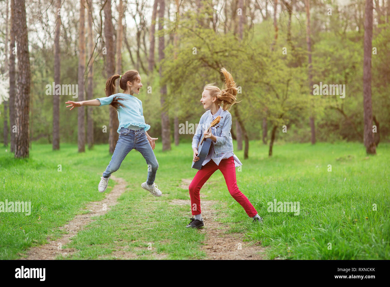 happy young rock band of two jumping and playing guitar little ...