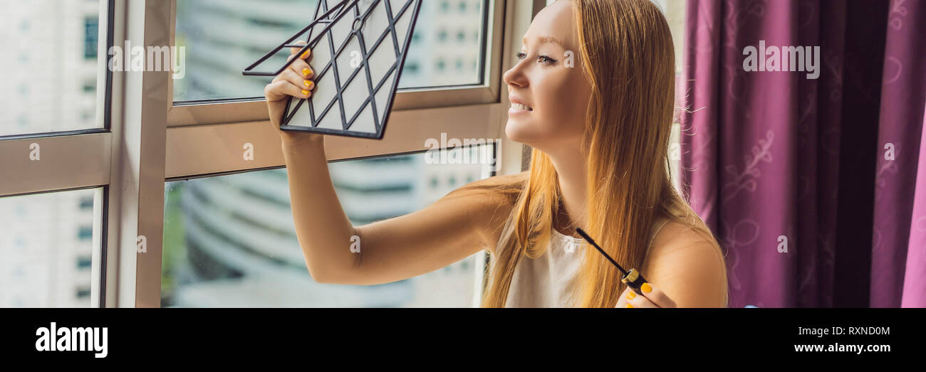 Young woman does makeup sitting by the window with a panoramic view of ...