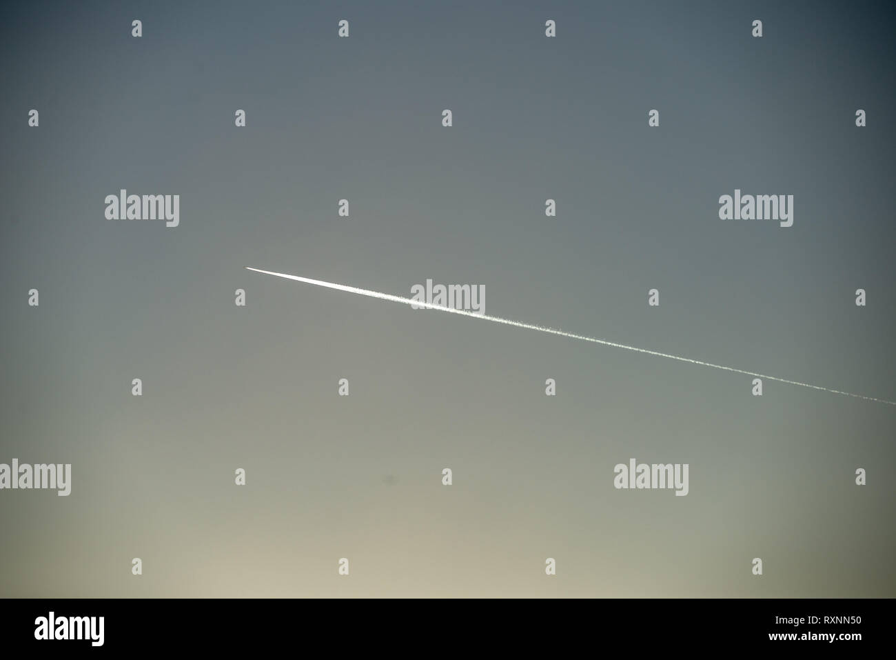 plane leaving smoke trail in the blue sky Stock Photo - Alamy