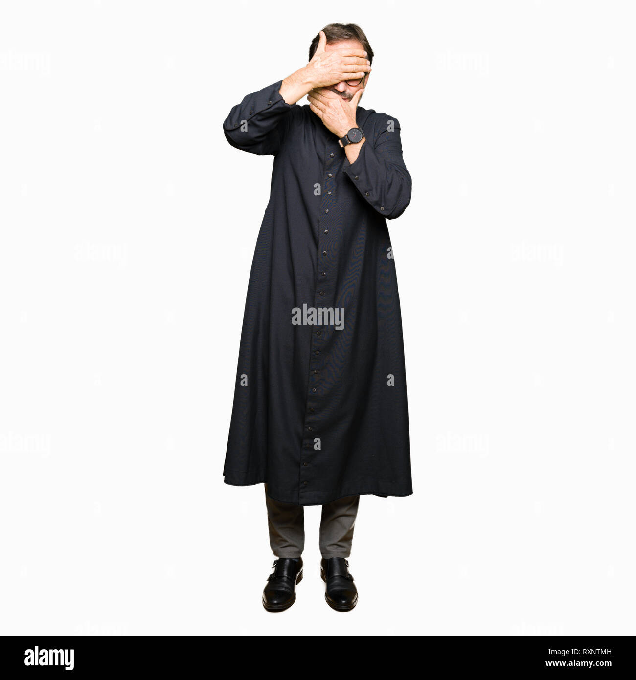 Middle age priest man wearing catholic robe Covering eyes and mouth ...
