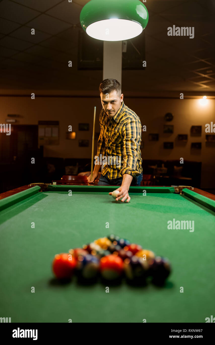 Male billiard player with cue aiming at the table Stock Photo - Alamy