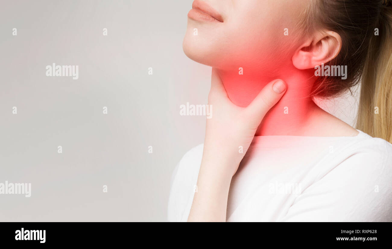Woman suffering from sore throat, touching her neck Stock Photo - Alamy
