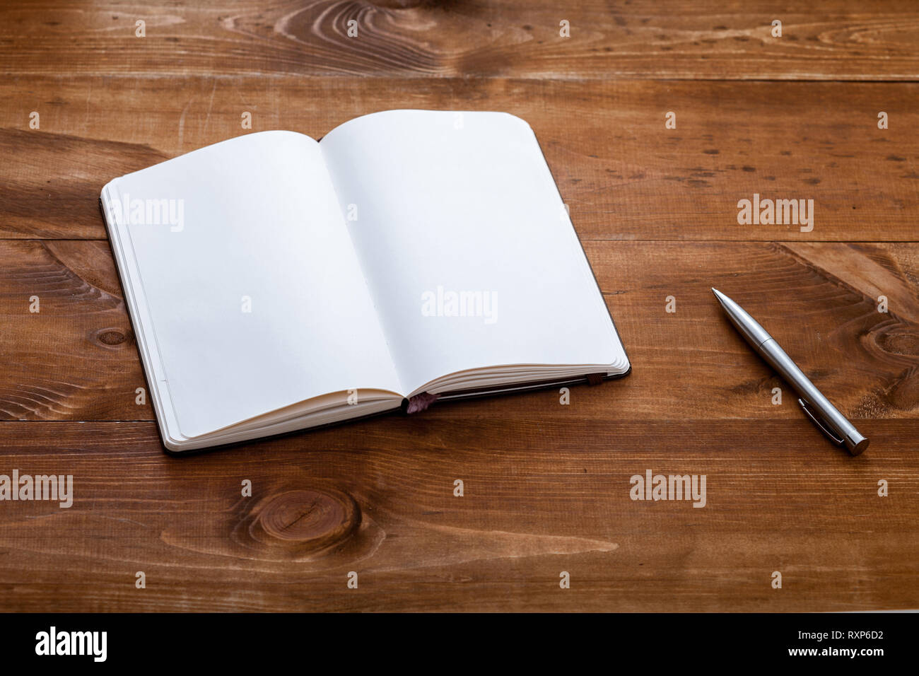Open blank empty paper notebook with pen on brown wooden desk, note ...