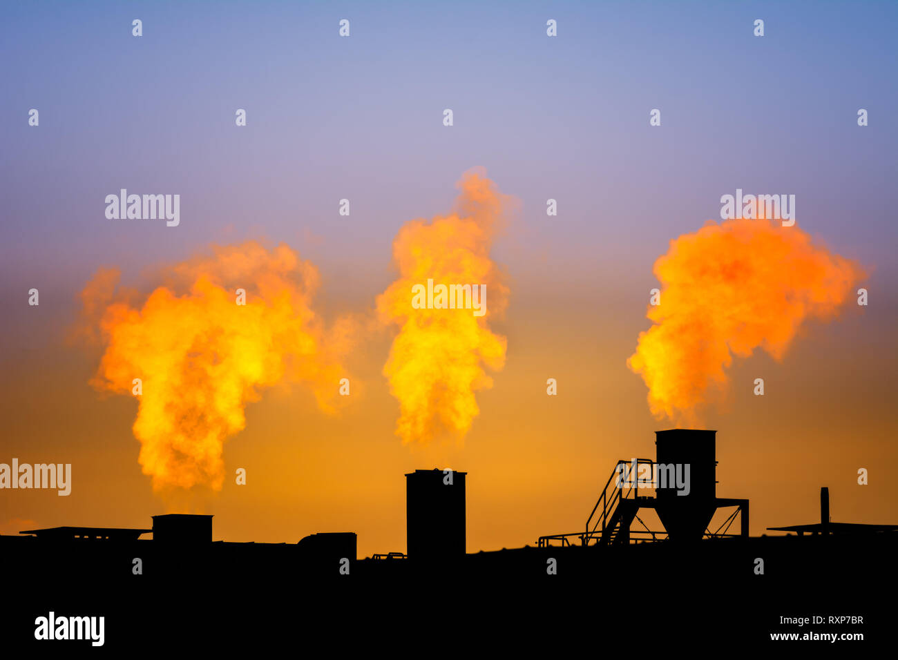 Chimneys with factory fumes at sunset hi-res stock photography and ...