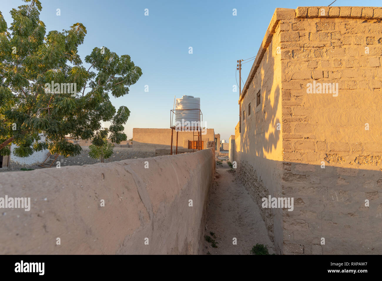 Narrow pedestrian alley and a water tank in the abandonned village of ...